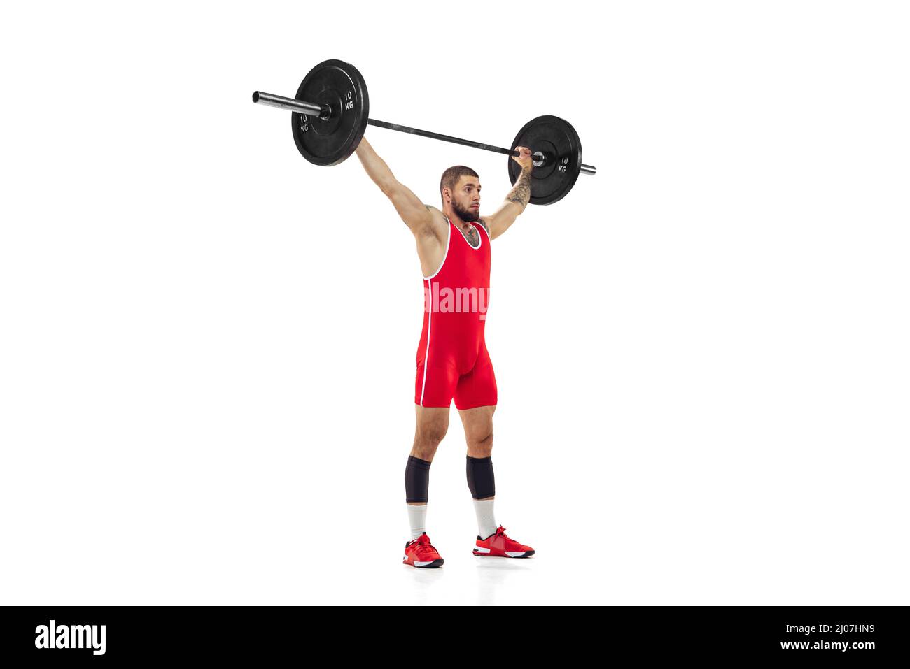 Full length portrait of man in red sportswear exercising with a weight ...