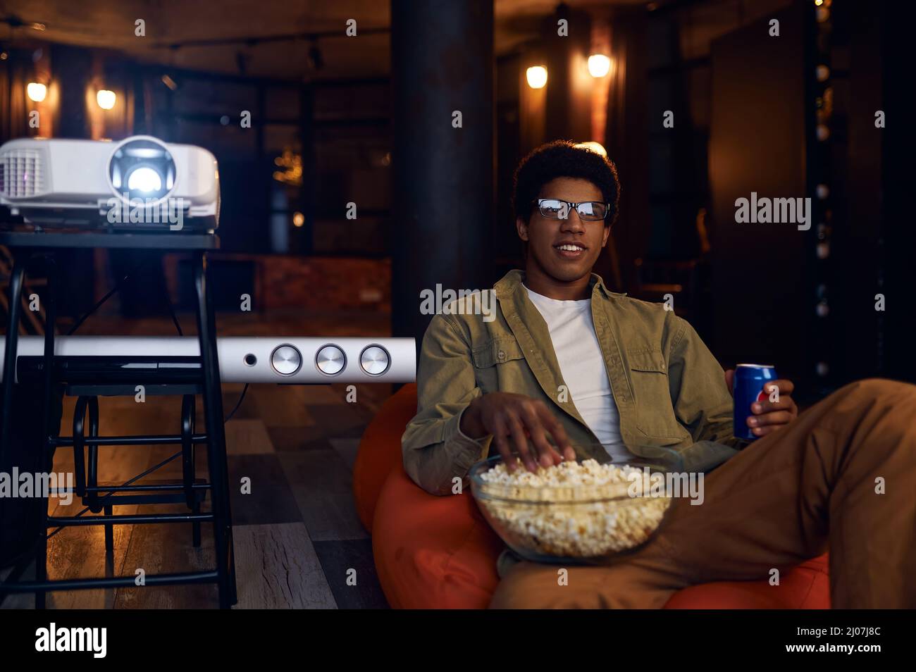 Man enjoy watching film using video projector Stock Photo - Alamy