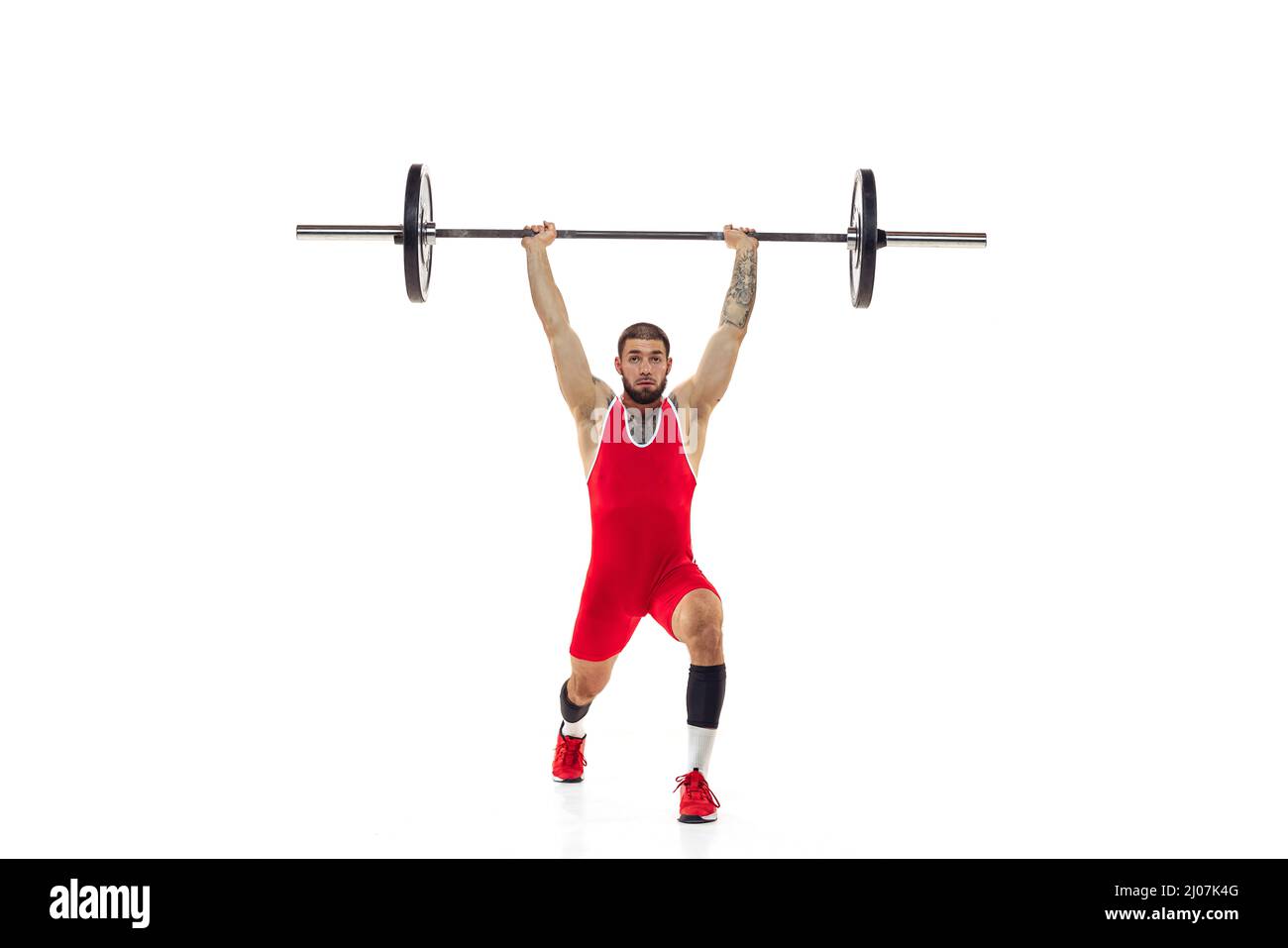 Full length portrait of man in red sportswear exercising with a weight ...
