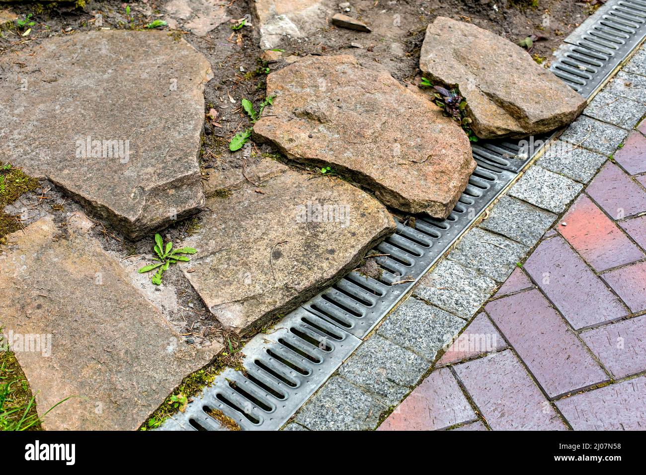 iron grating of the drainage system near pedestrian sidewalk made of ...