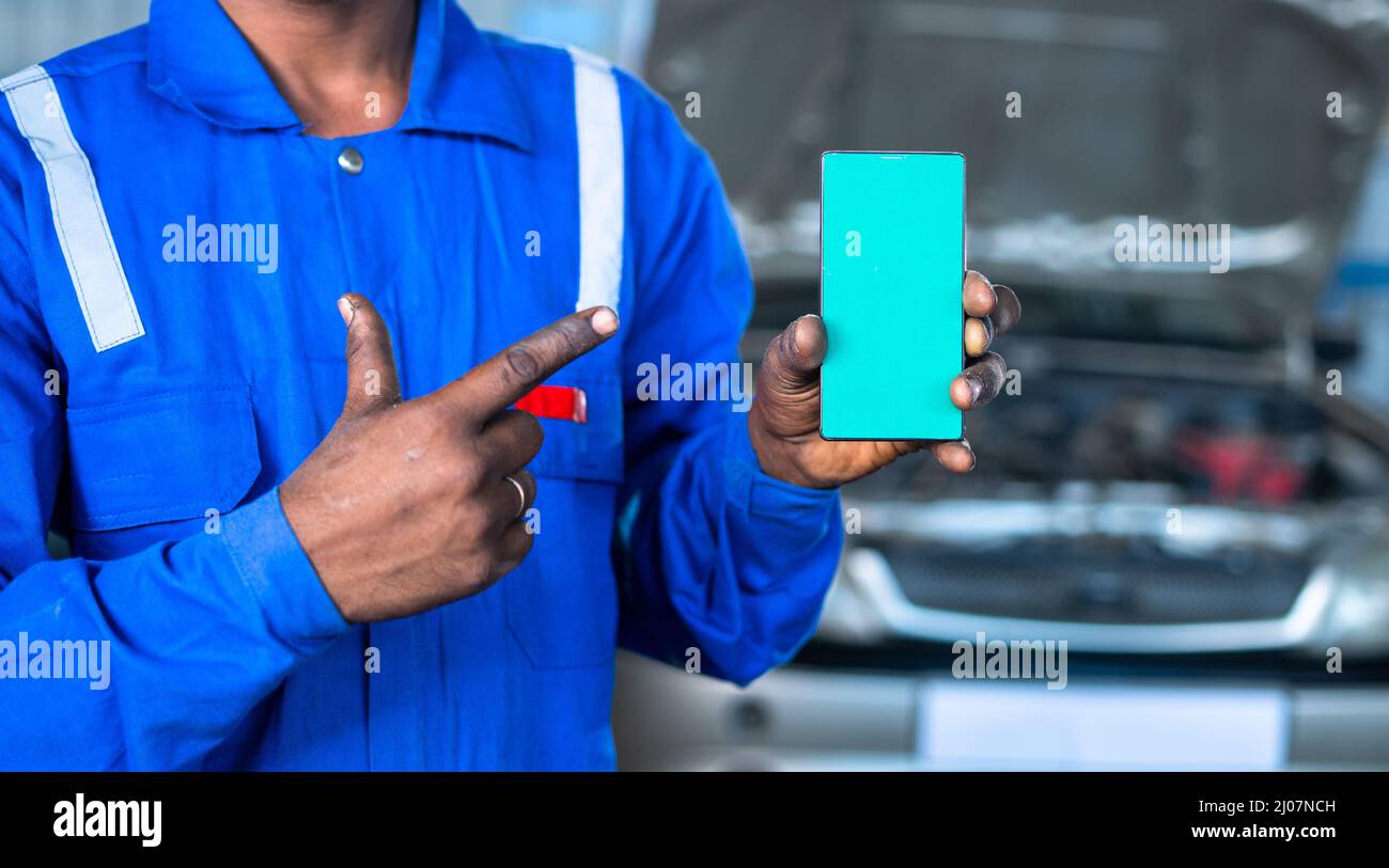 close up shot of car mechanic showing green screen mobile phone by ...