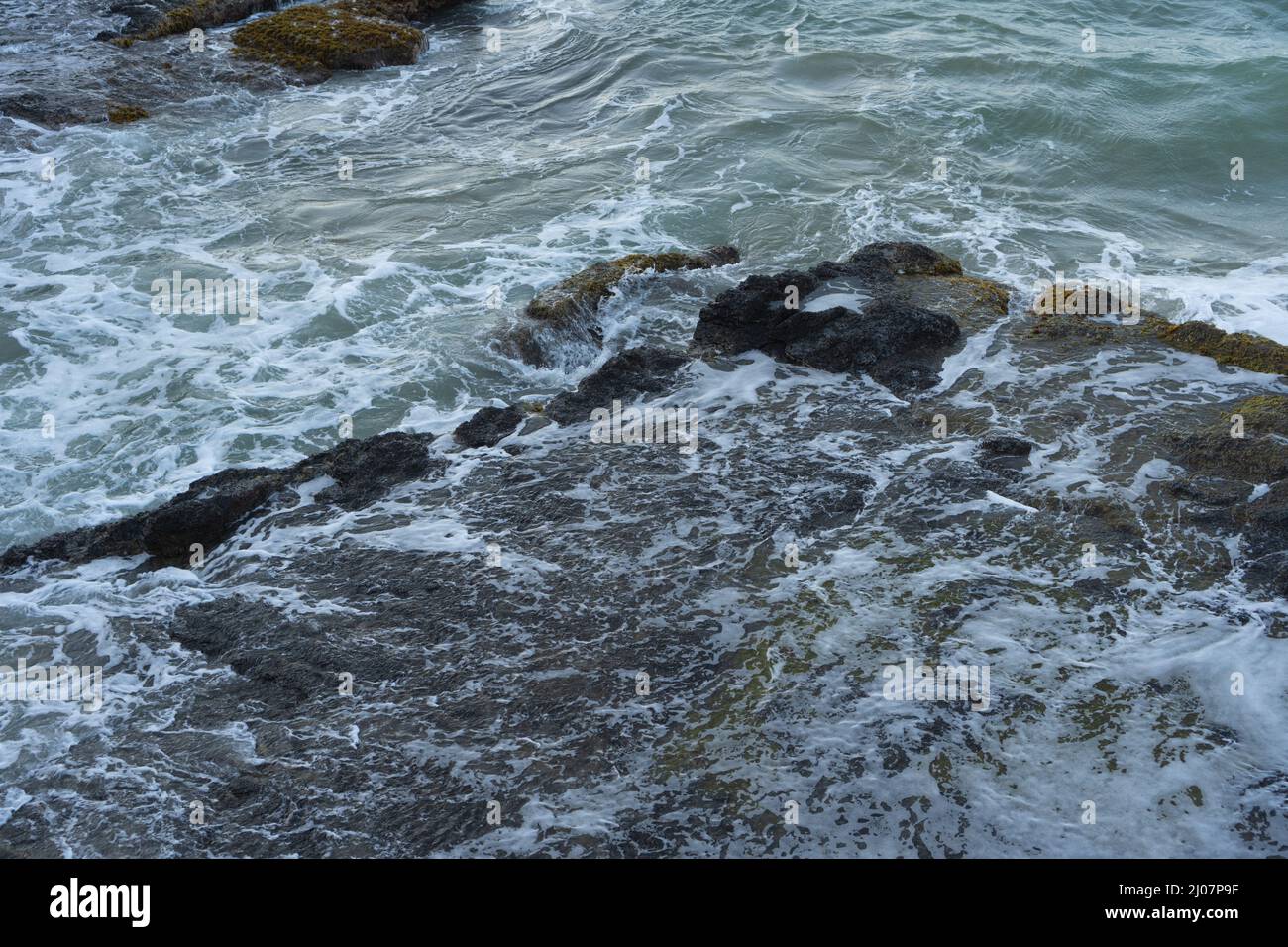 Sea waves lash line impact rock on the beach Stock Photo - Alamy