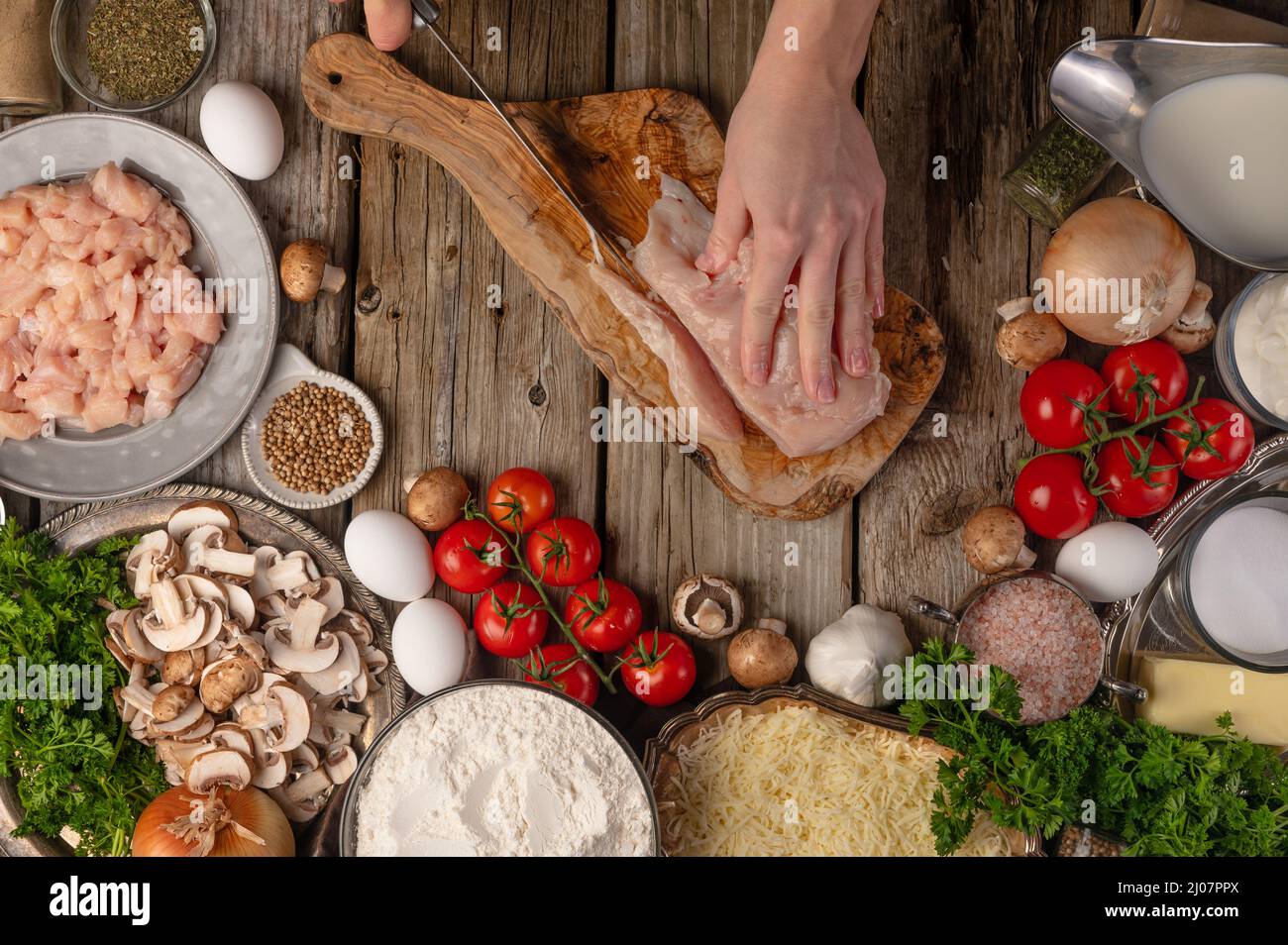 Chef hands cuts with knife chicken fillet for preparing meat filling on ...