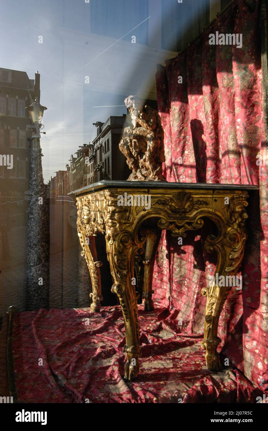 Antique shop display window with old table and figure, Amsterdam Stock ...