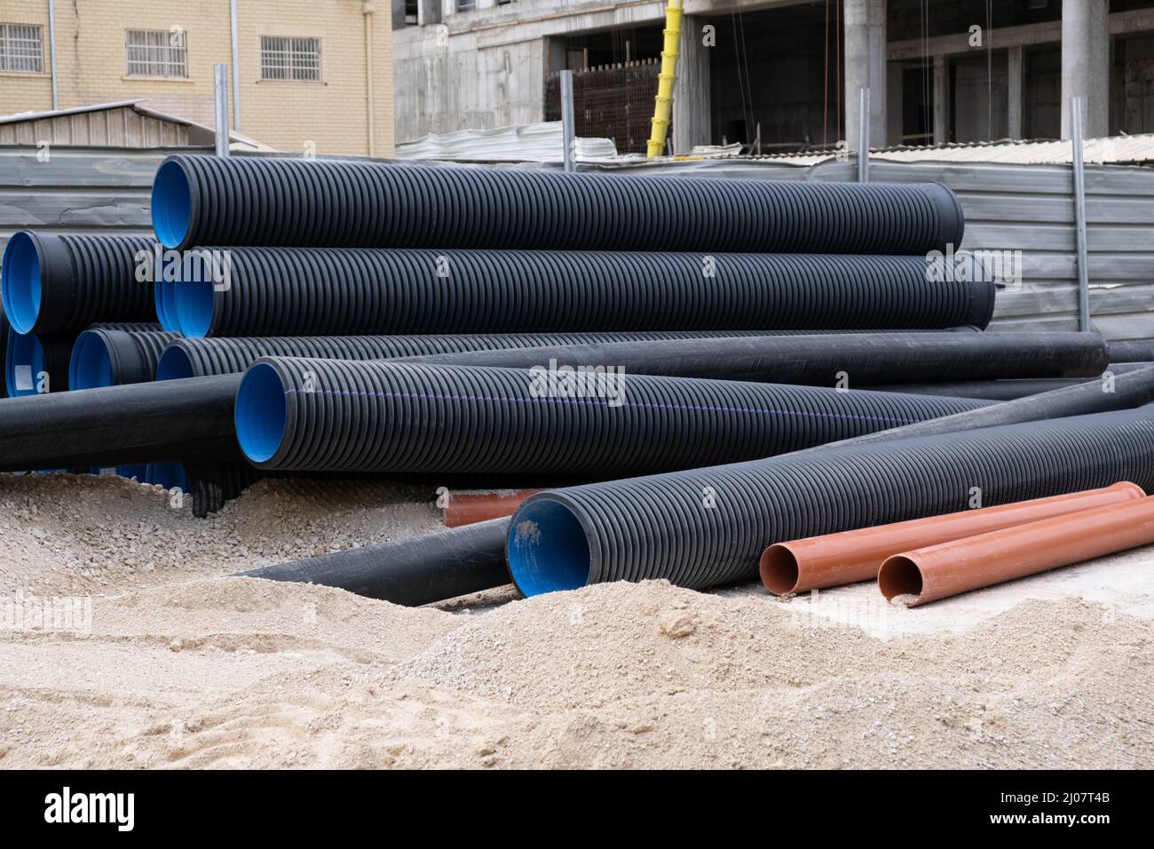Huge water and sewer a new pipe tube at a construction site, stacked ...