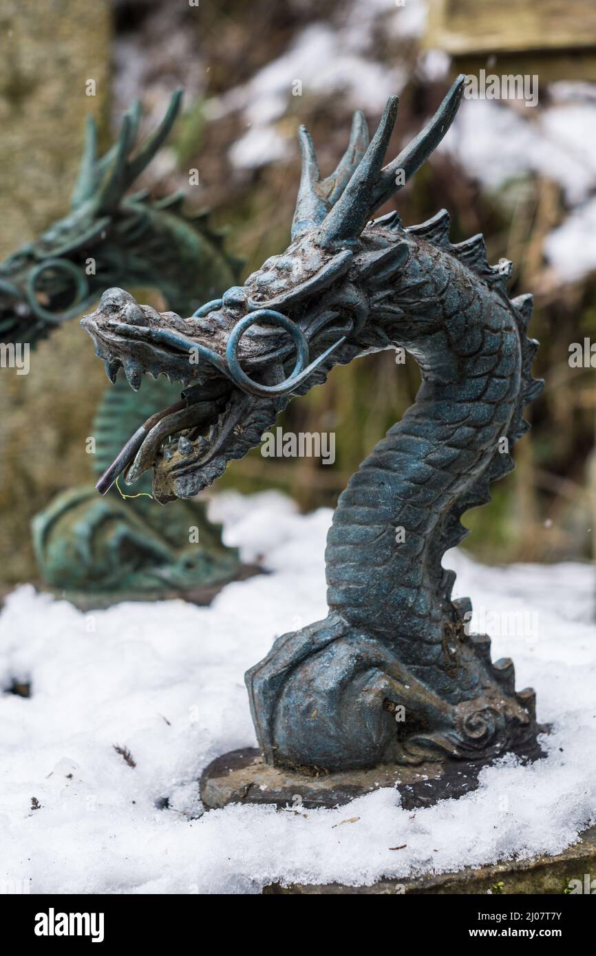 Close up detail of a metal dragon statue in the snow at a Japanese ...