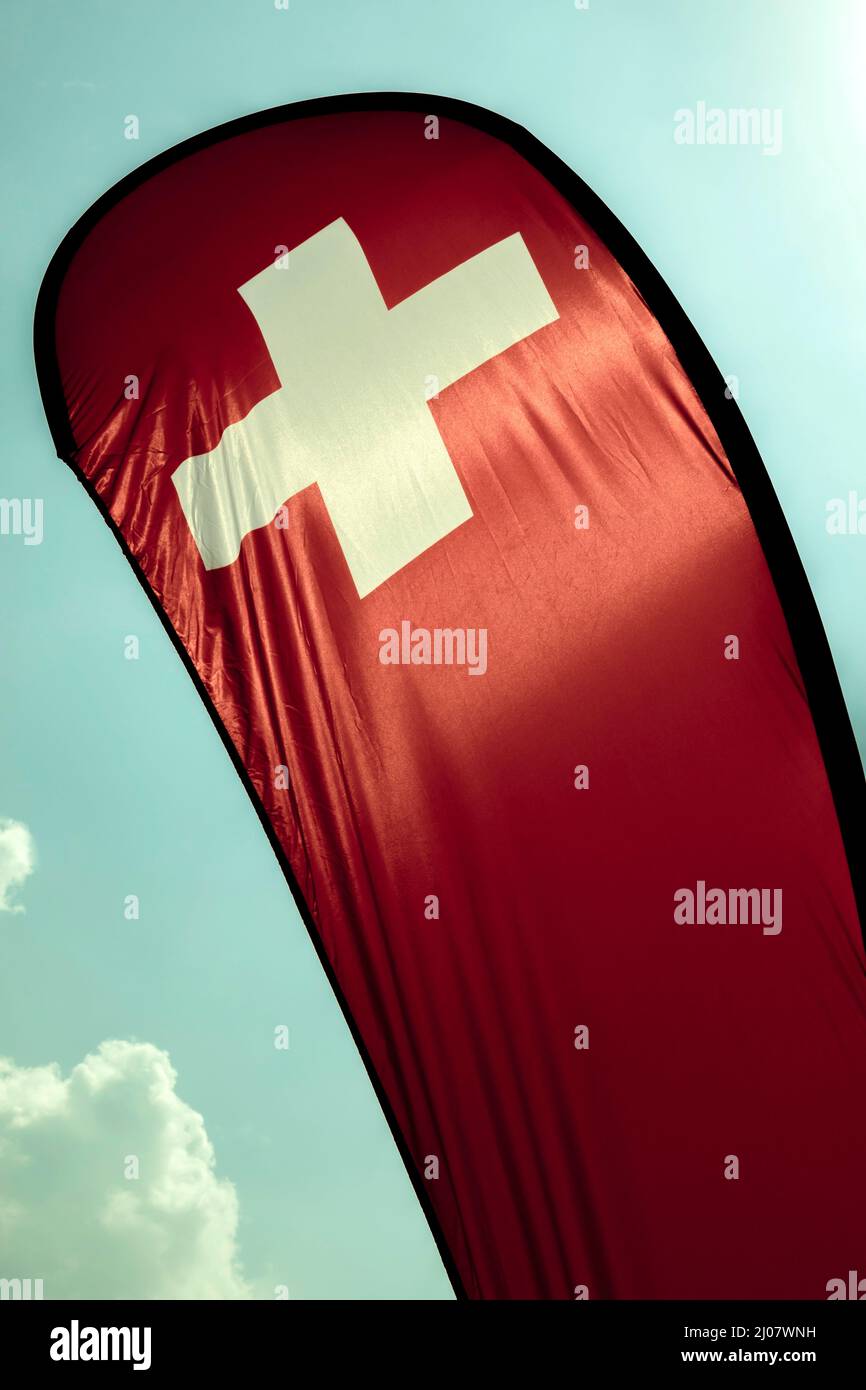 Swiss Banner Flag with Sunlight and Against Sky with Cloud. *** Local ...