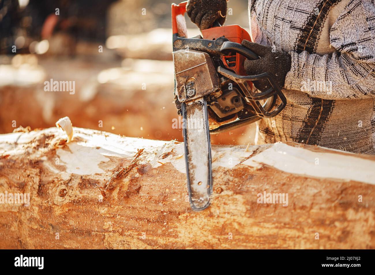 Industrial work carpenter sawing with chainsaw log, construction frame ...