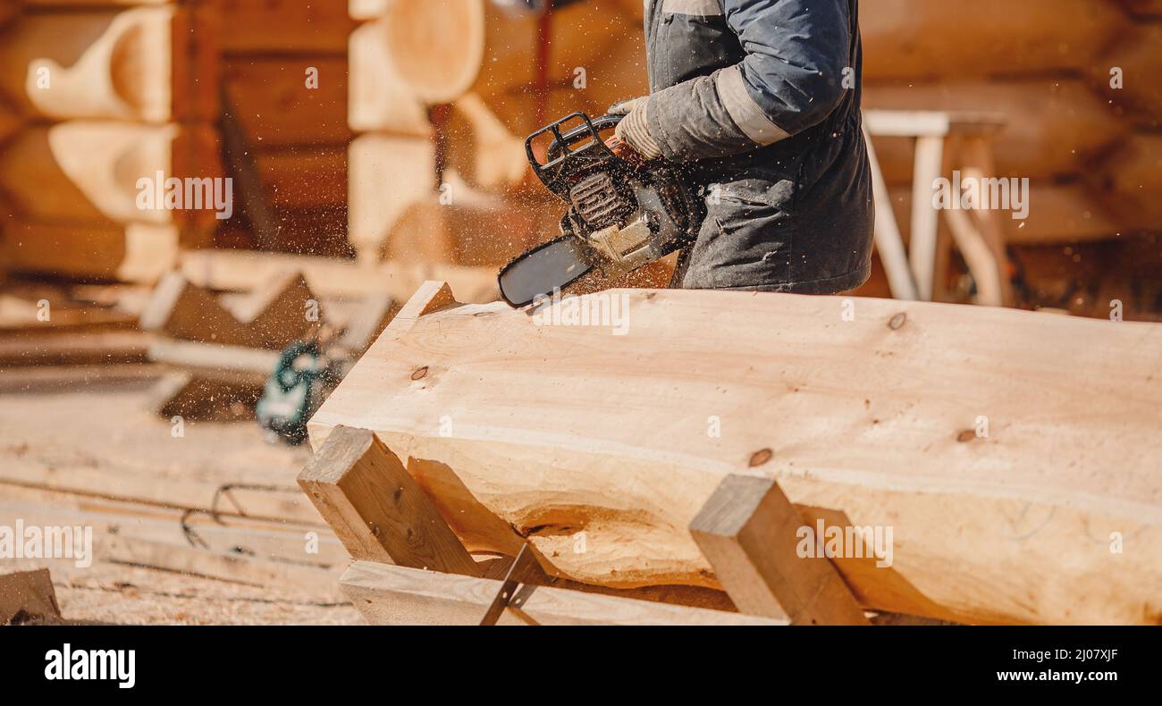 Sawmill logging. Lumberjack wielding chainsaw to cut log Stock Photo ...
