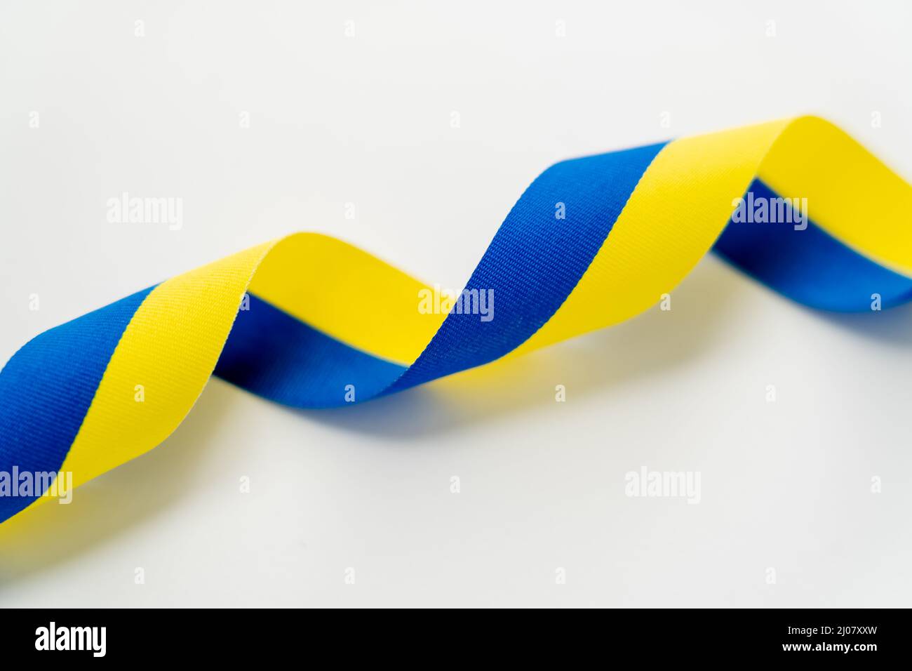 Close up view of curly blue and yellow ribbon on white background Stock ...