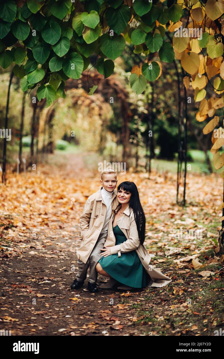 Mom And Son Are On Good Terms Walking In The Park Chatting Stylish