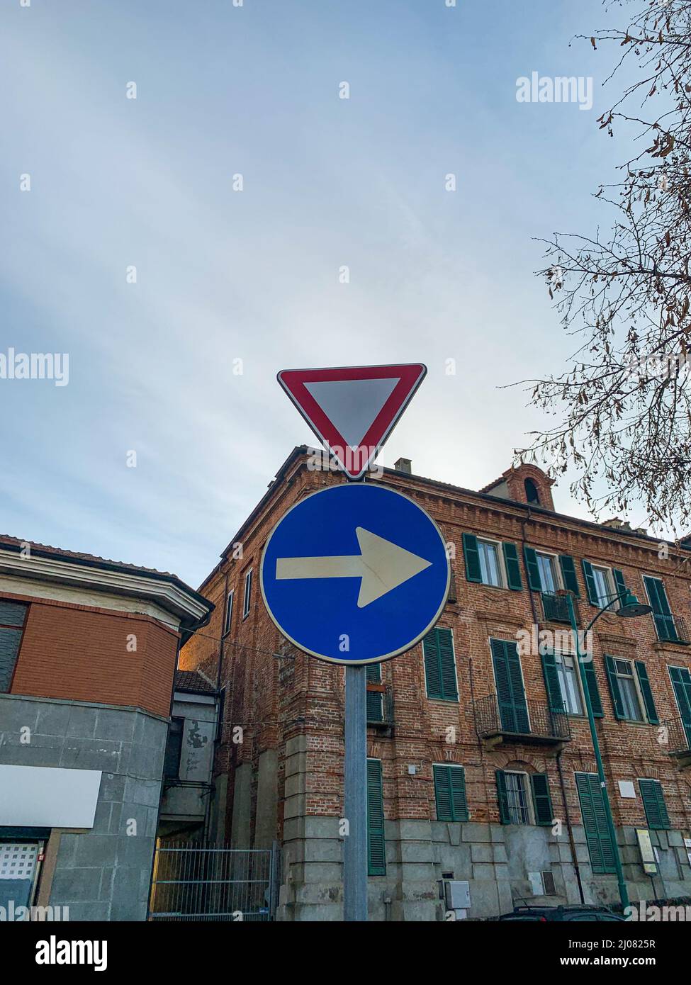 Vertical shot of give way and turn right road signs Stock Photo - Alamy