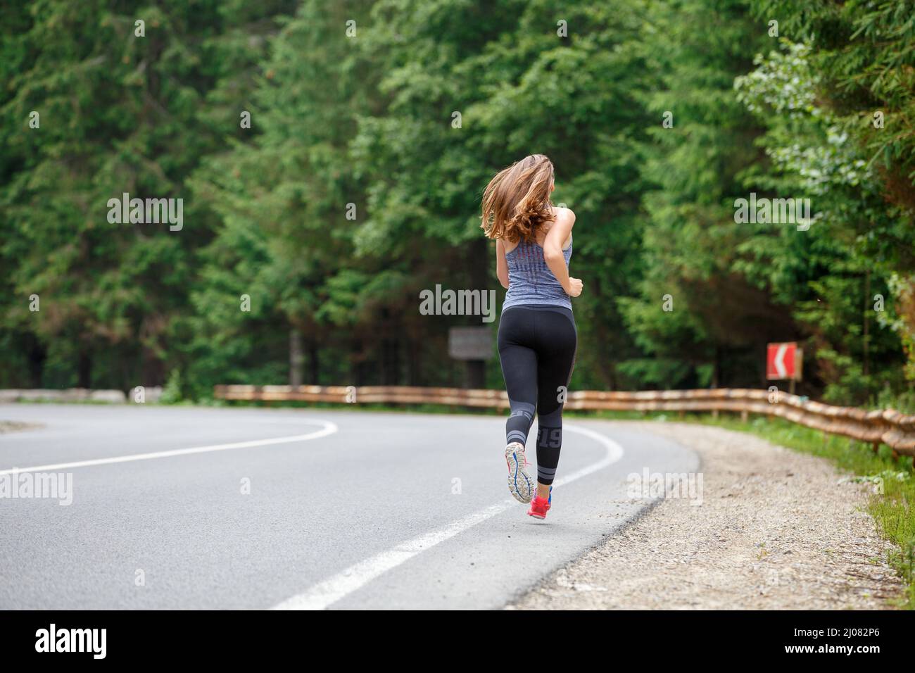 Runner woman running on the mountain road through the forest Stock ...