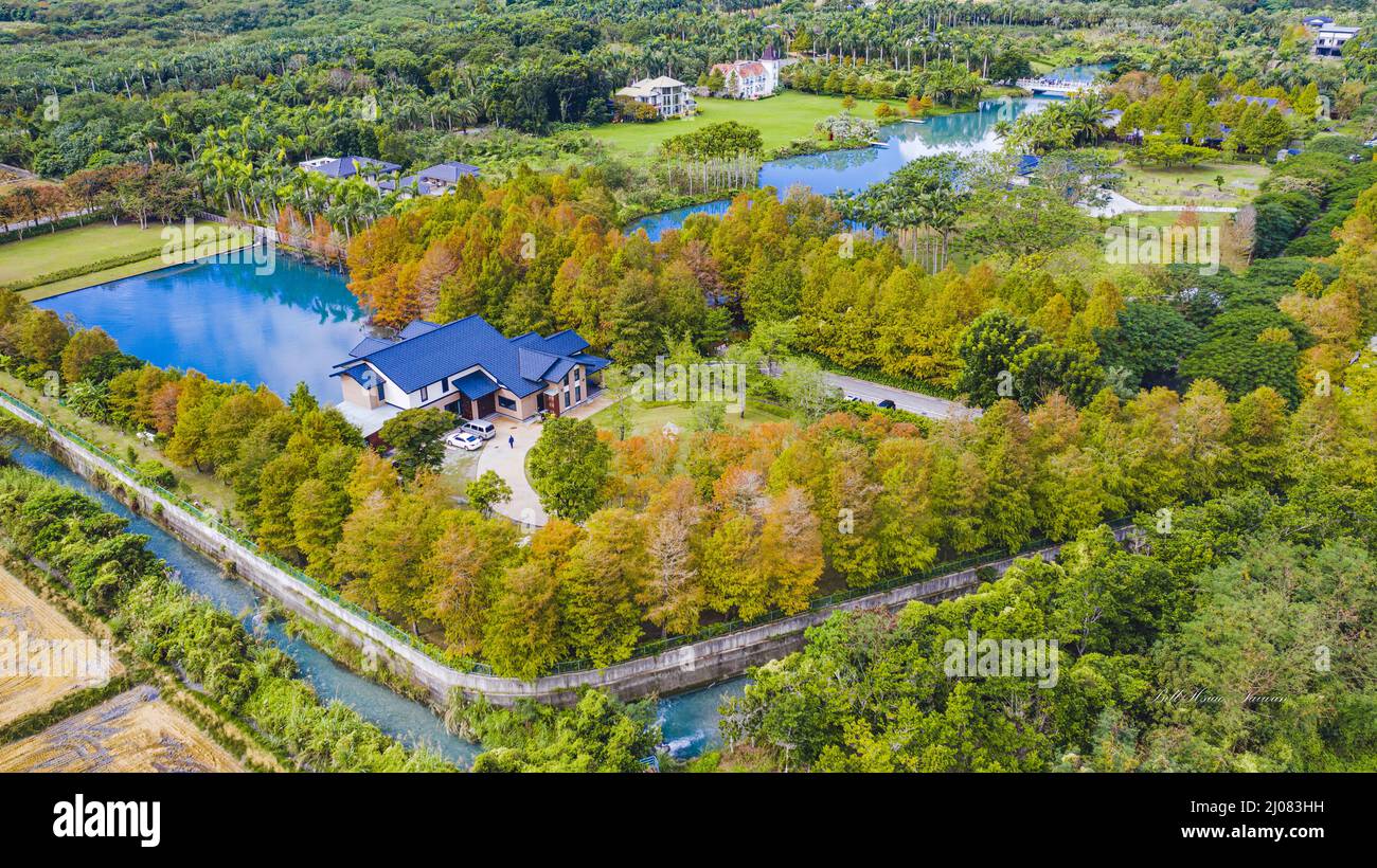 Birds eye view on small villa surrounded by forest and river going near ...