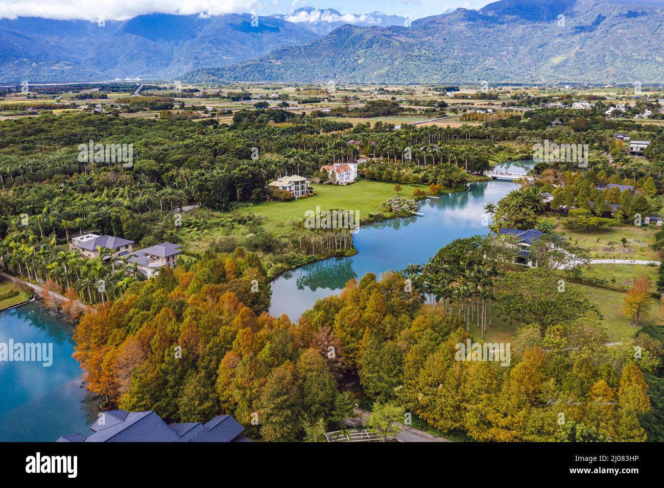 Birds eye view on small villas surrounded by forest and river going ...