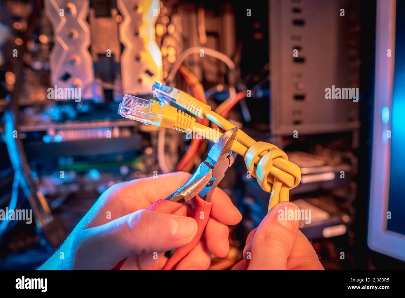 Cutting the Internet cable tied into a knot with wire cutters. The ...