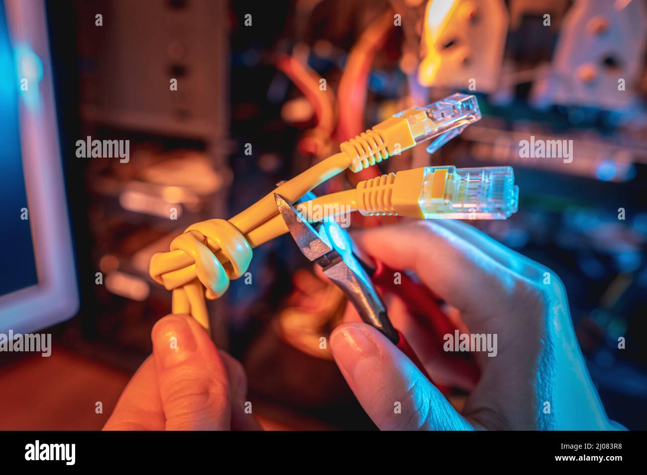 Cutting the Internet cable tied into a knot with wire cutters. The ...
