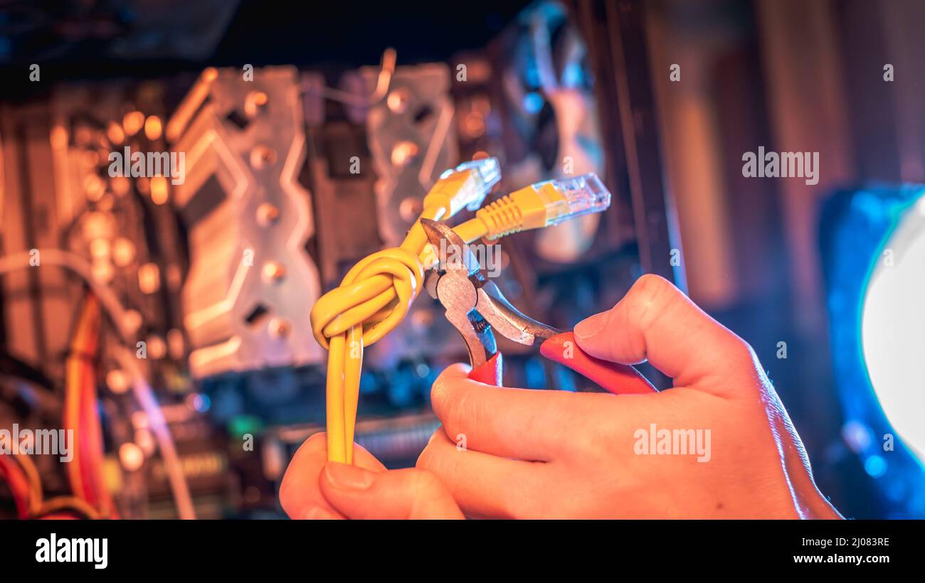 Cutting the Internet cable tied into a knot with wire cutters. The ...