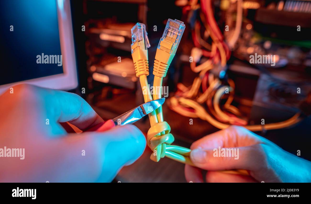 Cutting the Internet cable tied into a knot with wire cutters. The ...