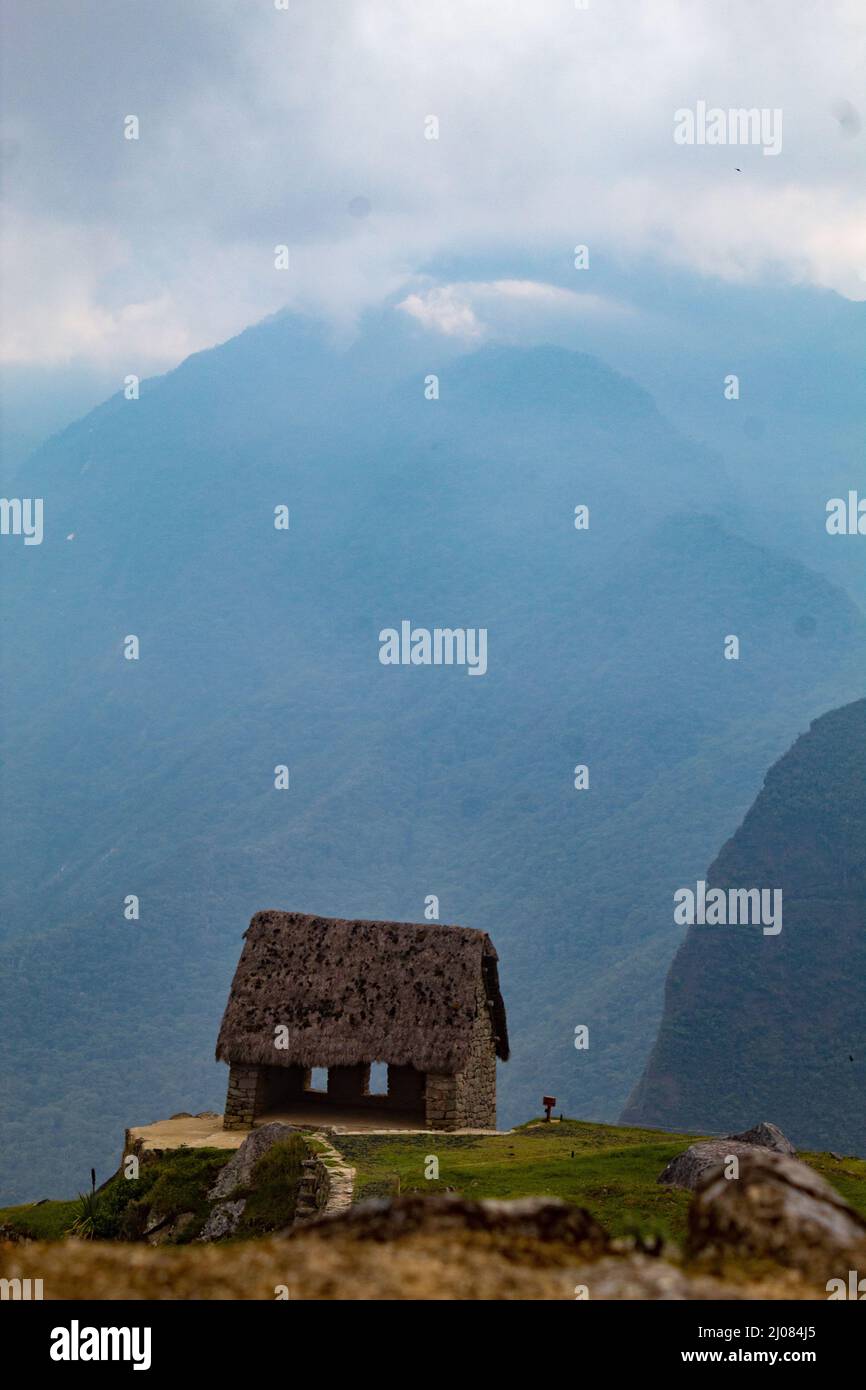 Ancient brick house on the peak with the mountains and clouds in ...