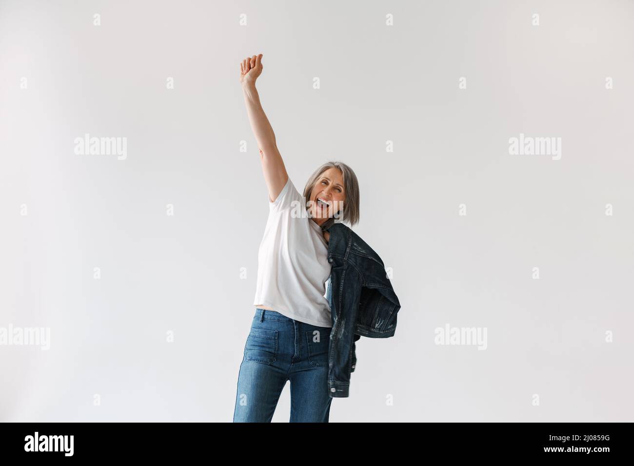 Grey senior woman screaming while making winner gesture isolated over ...