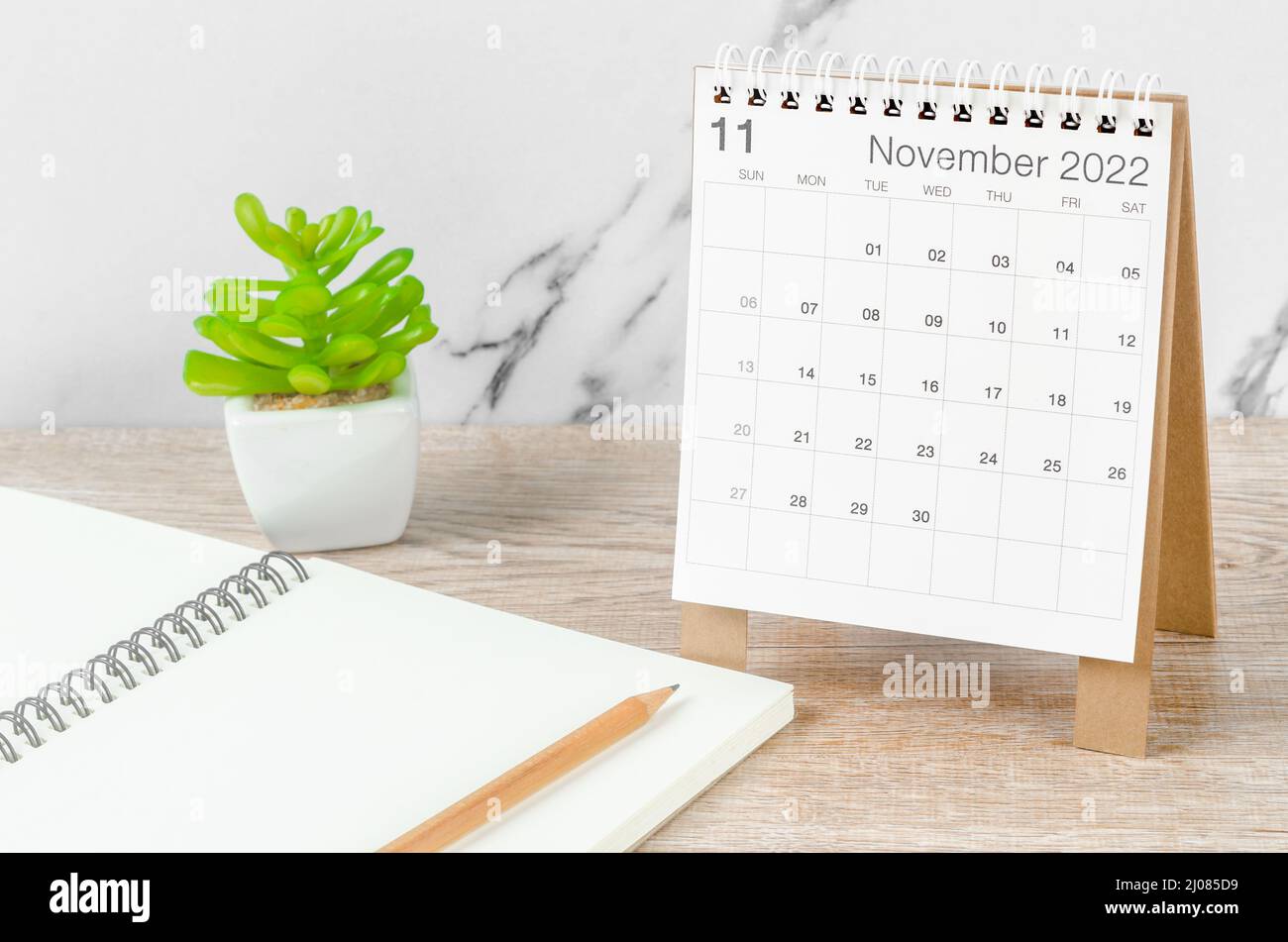 The November 2022 desk calendar with plant on wooden table Stock Photo ...