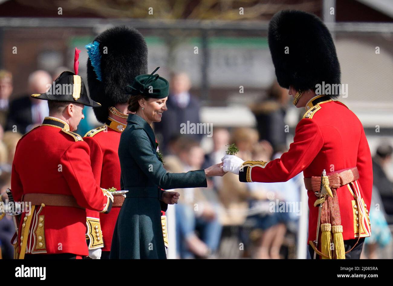 The Duchess of Cambridge hands sprigs of shamrock to an officer during ...
