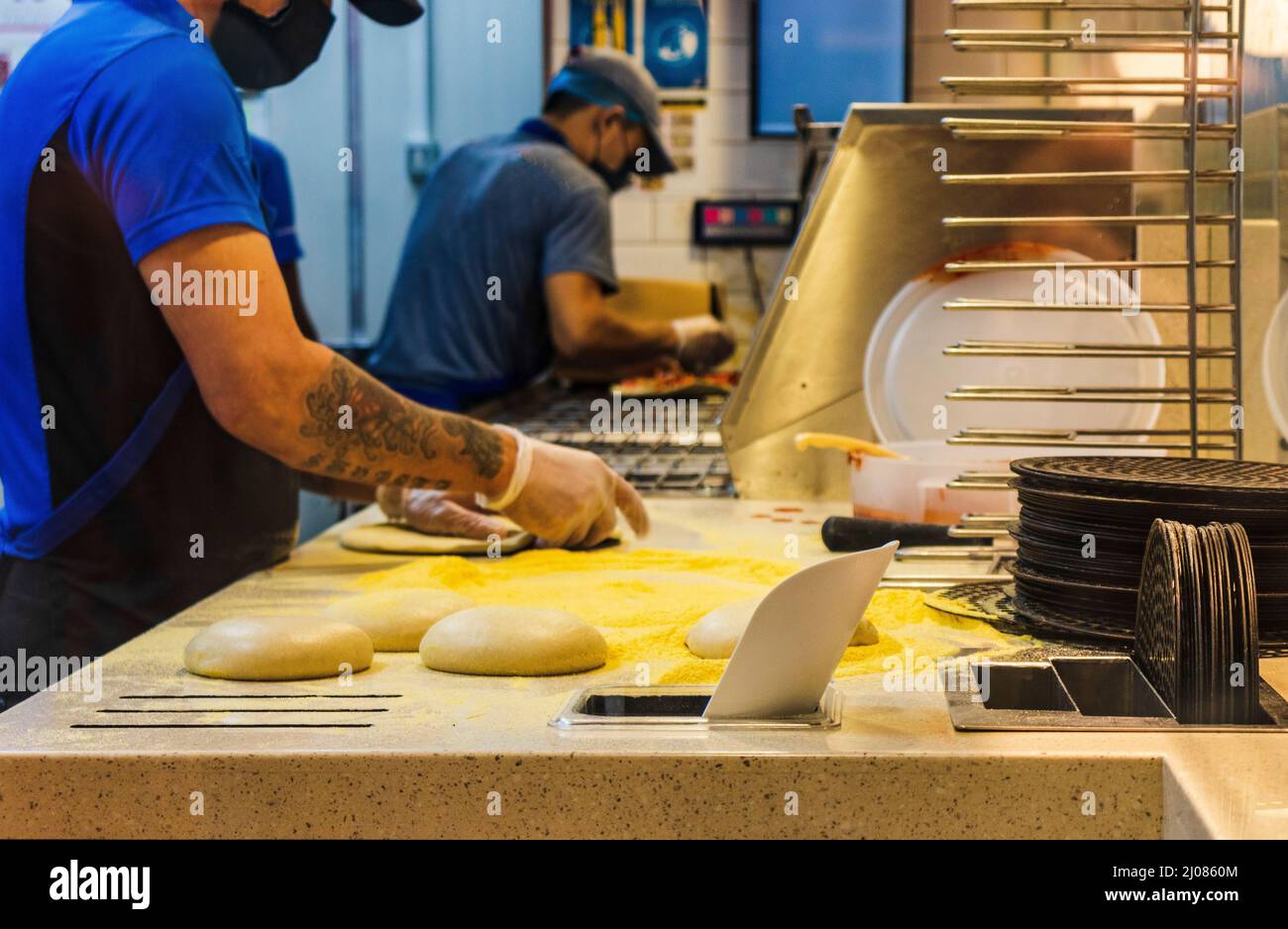 Workers preparing pizza in the kitchen of the restaurant Stock Photo ...