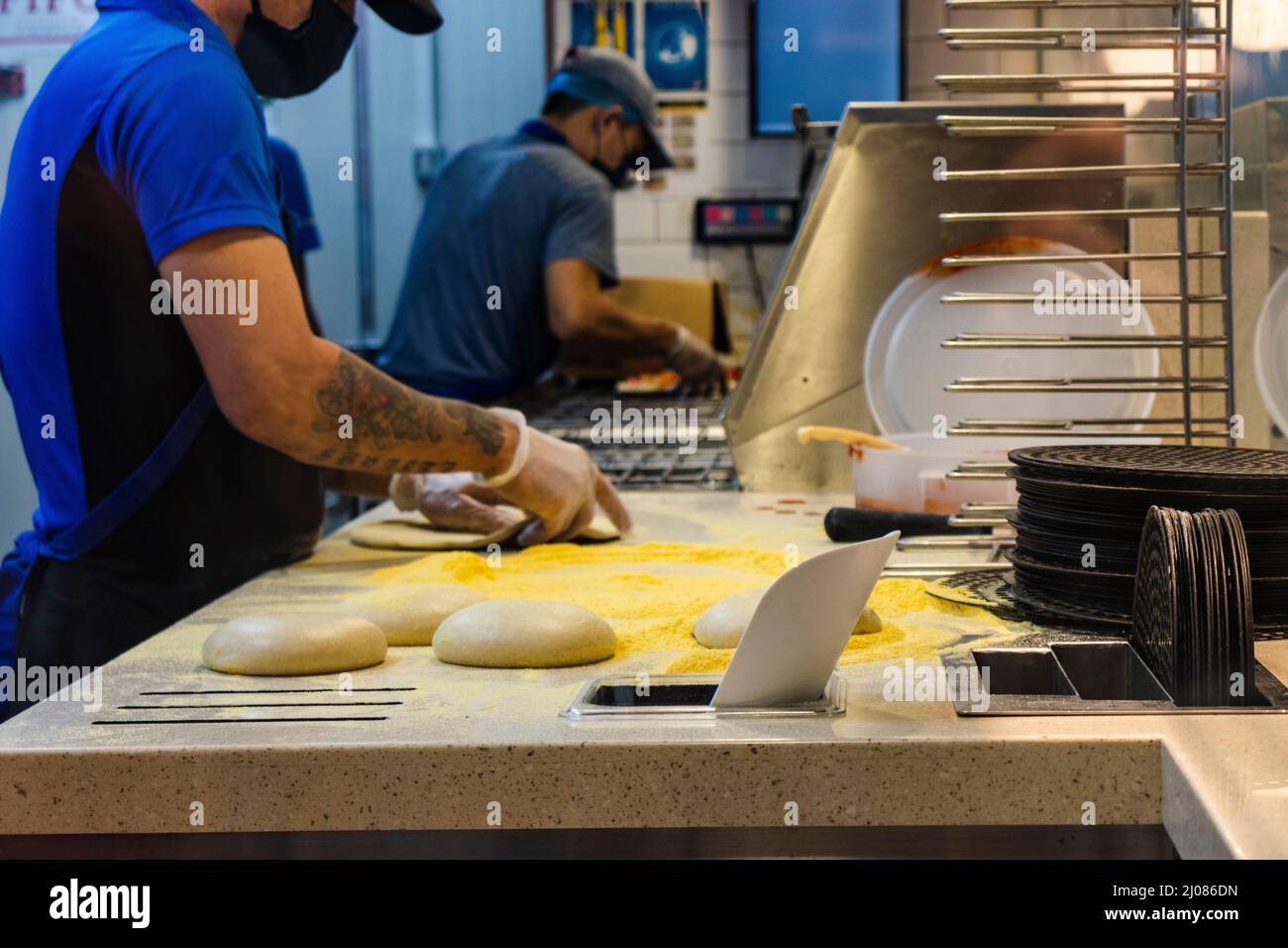 Workers preparing pizza in the kitchen of the restaurant Stock Photo ...