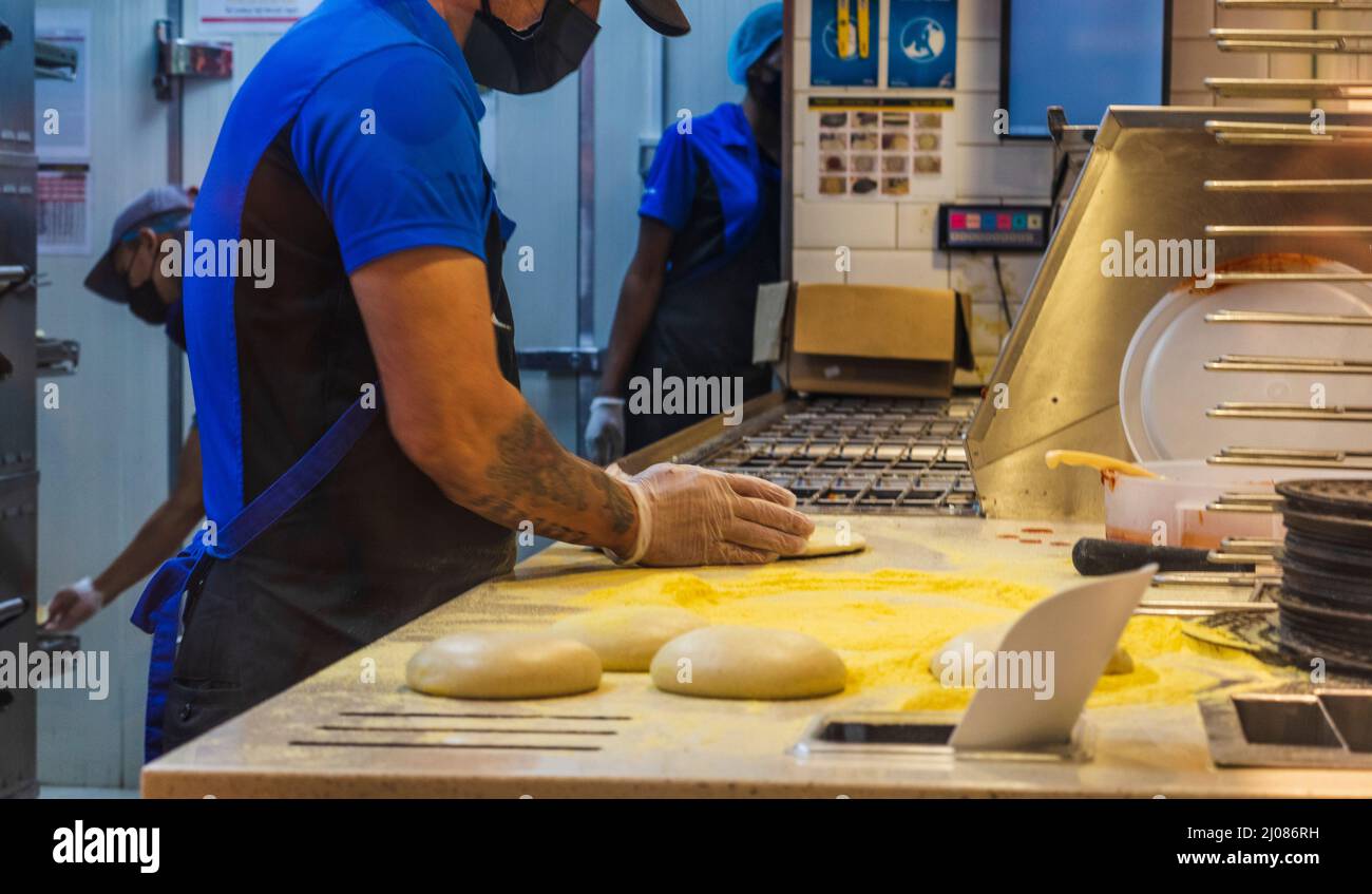 Workers preparing pizza in the kitchen of the restaurant Stock Photo ...