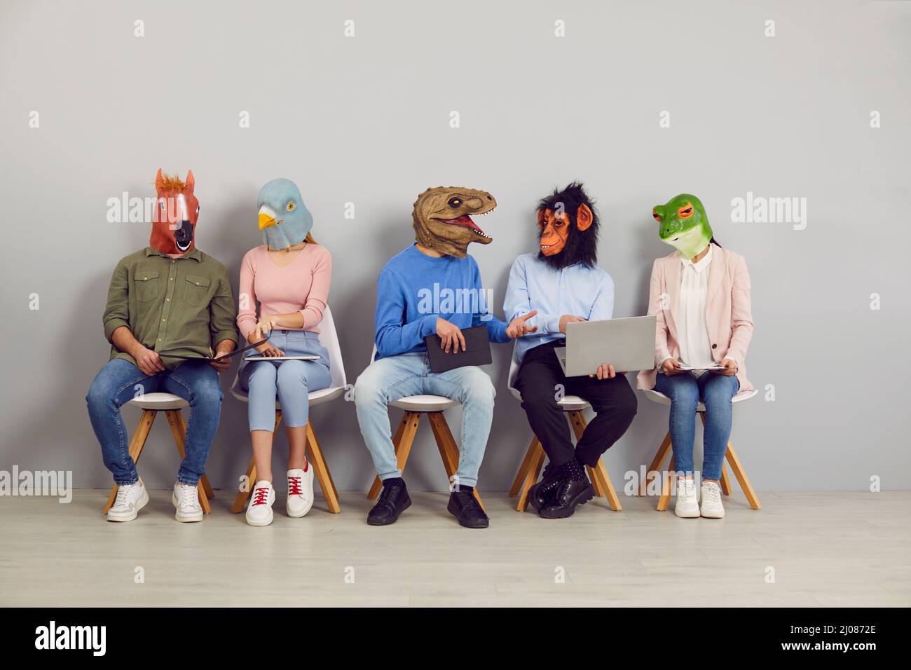 People in funny animal masks talking and using devices while waiting ...