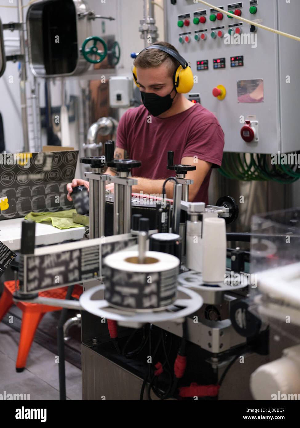 Man working packing beer cans in a factory Stock Photo - Alamy