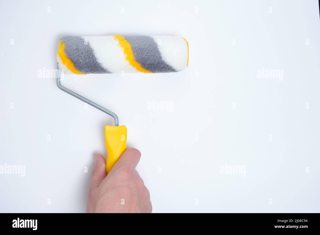 Paint roller in hand for painting walls and repairs on white background ...