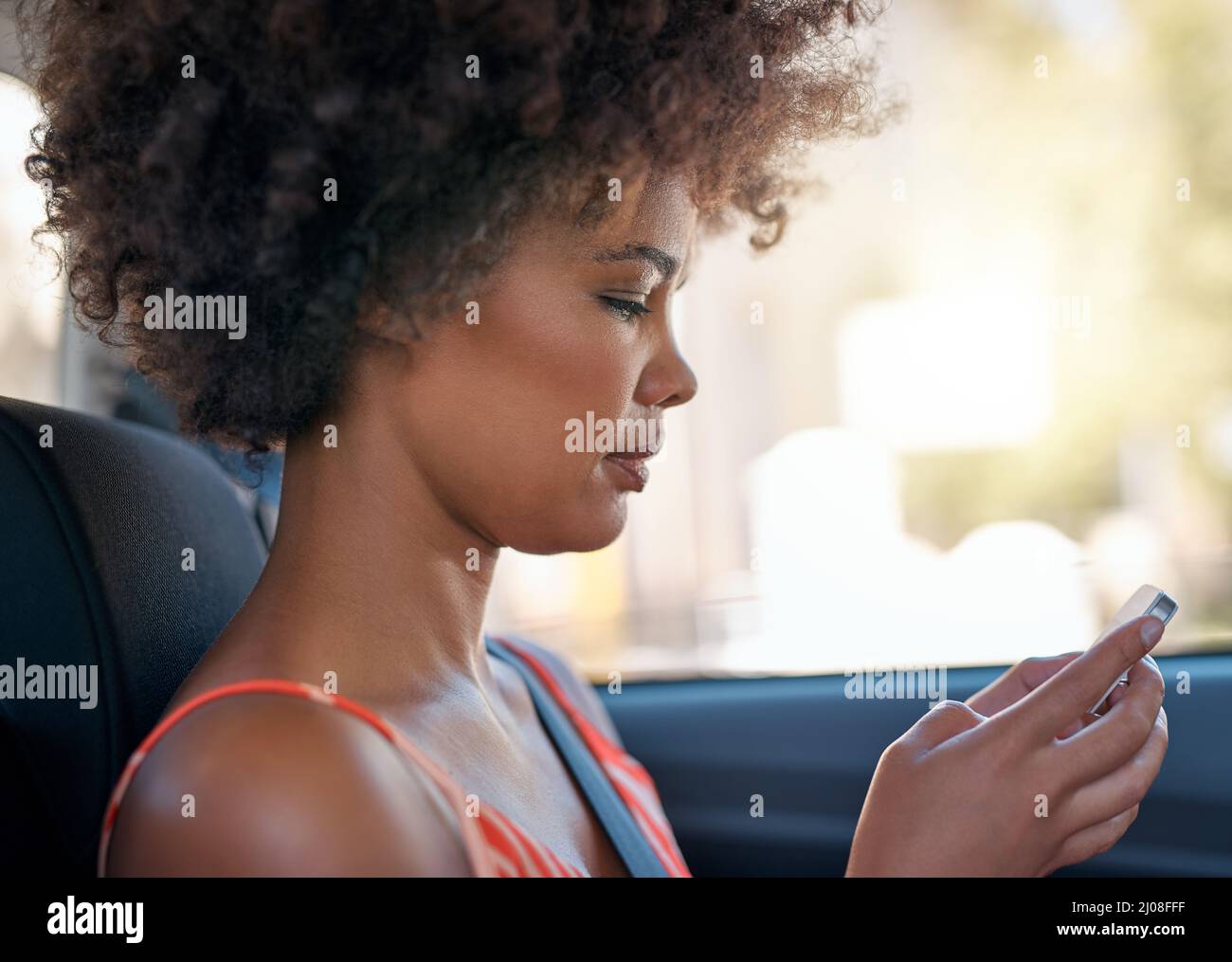 Texting on the move. Cropped shot of an attractive young woman sending ...