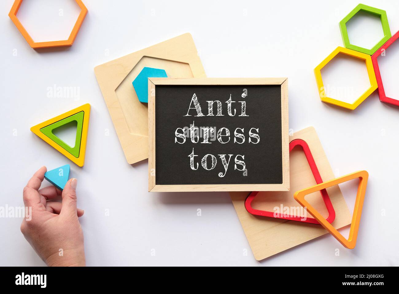 Text Anti stress toys on white blackboard. Nested wood triangles and ...