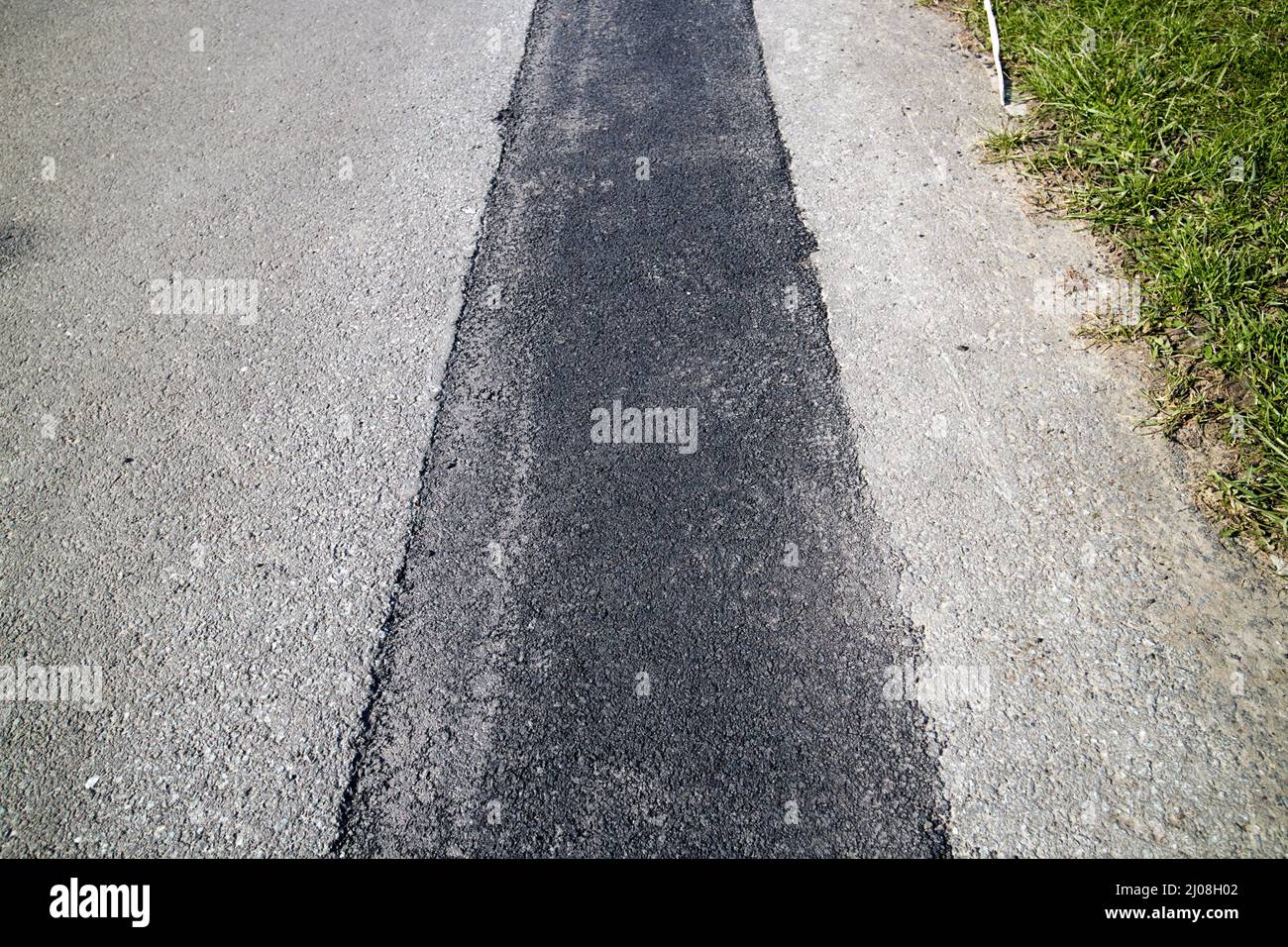recently dug up and refilled utlities trench tarmaced over in footpath ...
