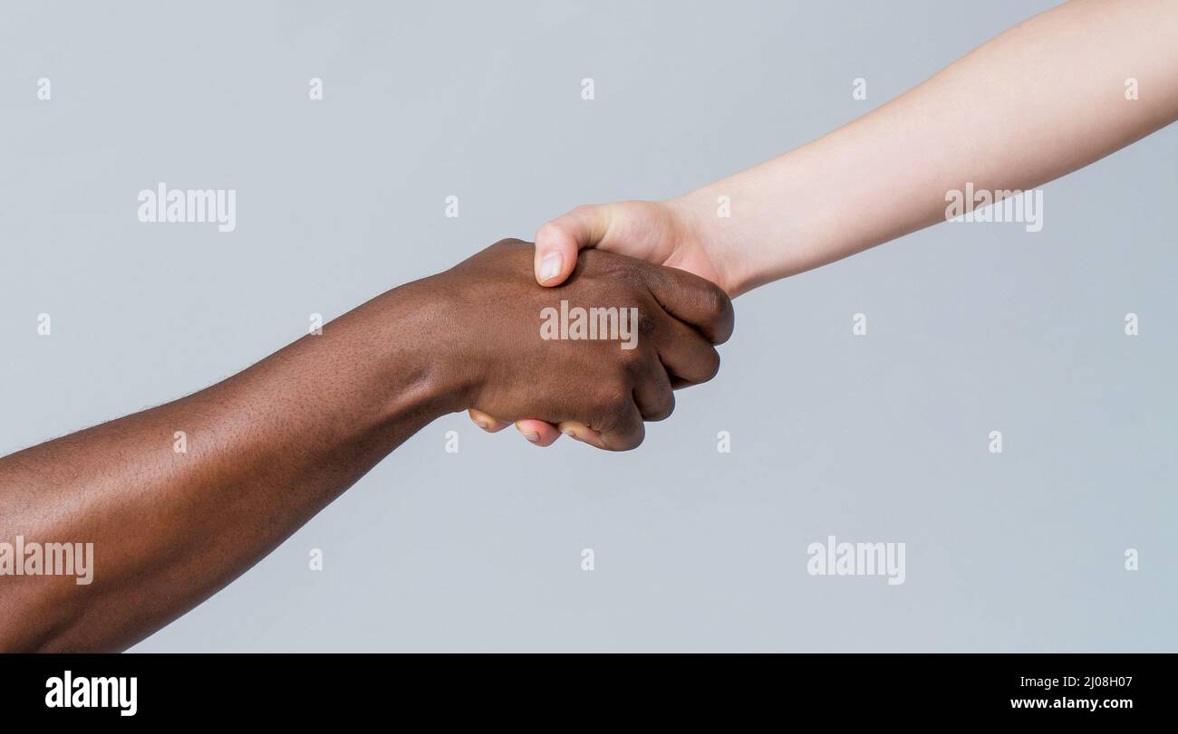 Black and white human hands. African and caucasian hands. Giving a ...