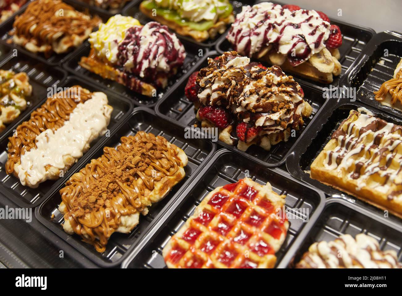 Various of traditional Belgian waffles topped with chocolate, speculoos ...