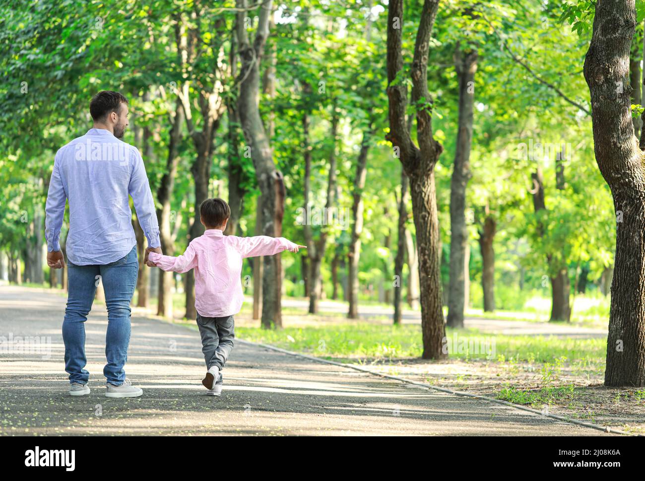 Father walking with his little son in park Stock Photo - Alamy