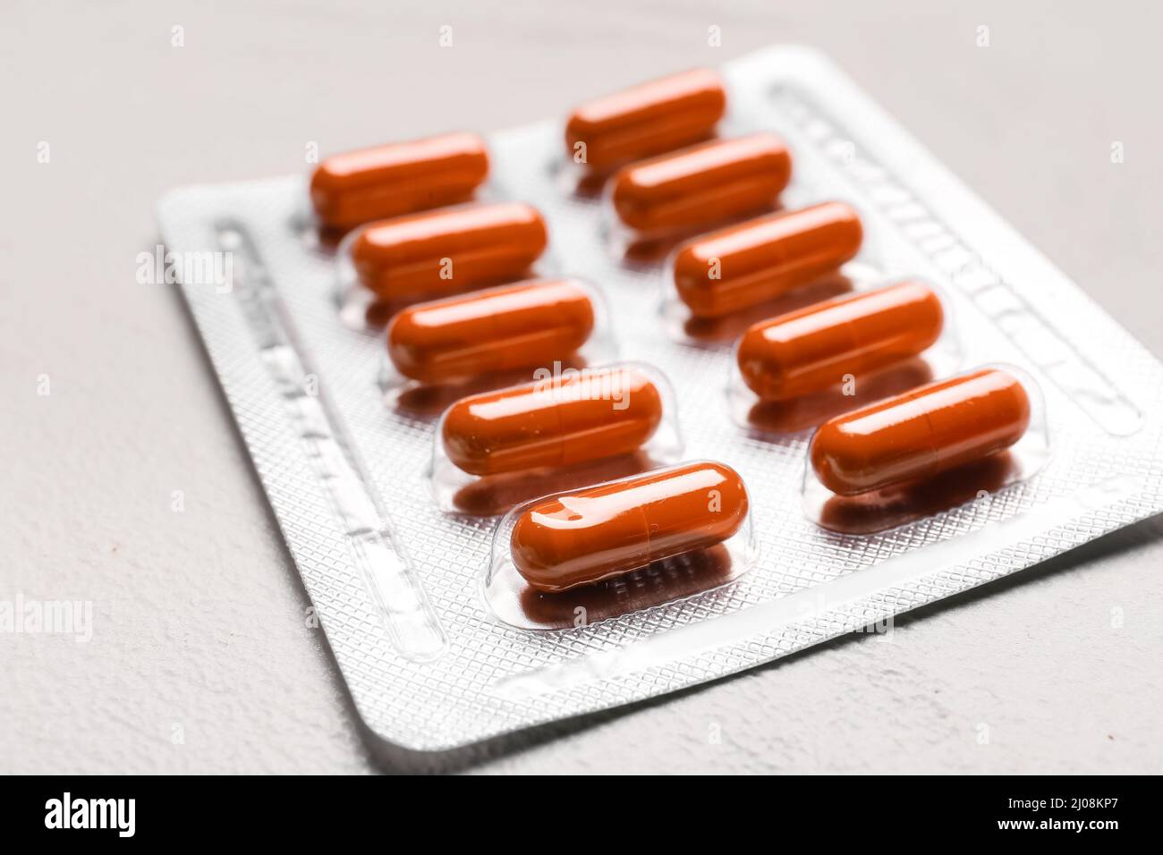 Blister pack with turmeric powder capsules on white background, closeup ...
