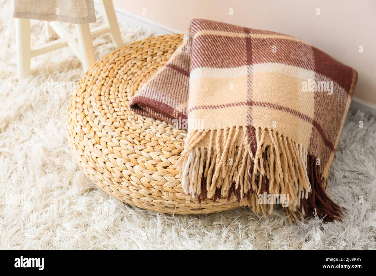 Modern pouf with plaid in room, closeup Stock Photo - Alamy