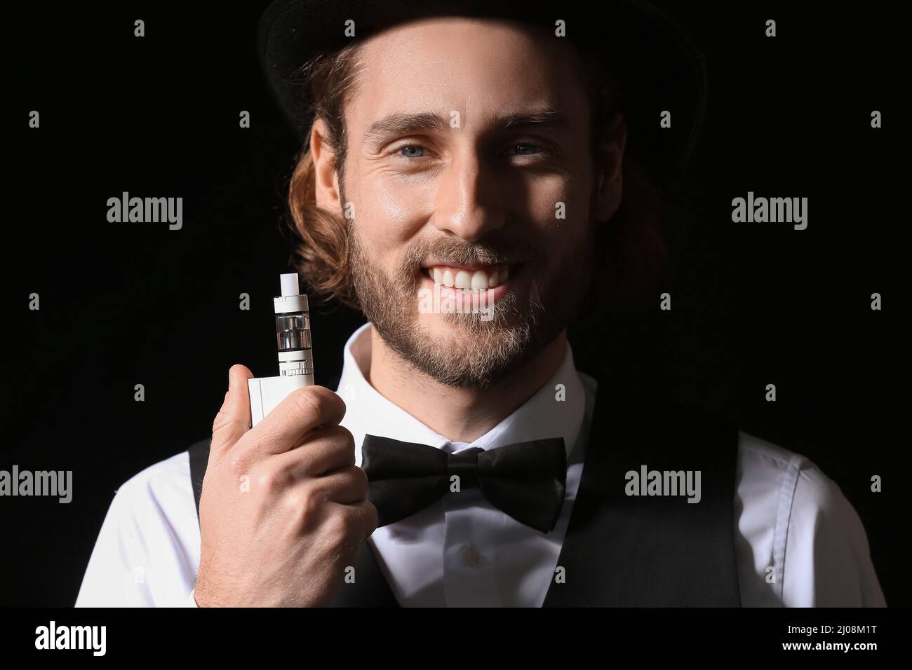 Handsome young man with vape mod on black background Stock Photo - Alamy