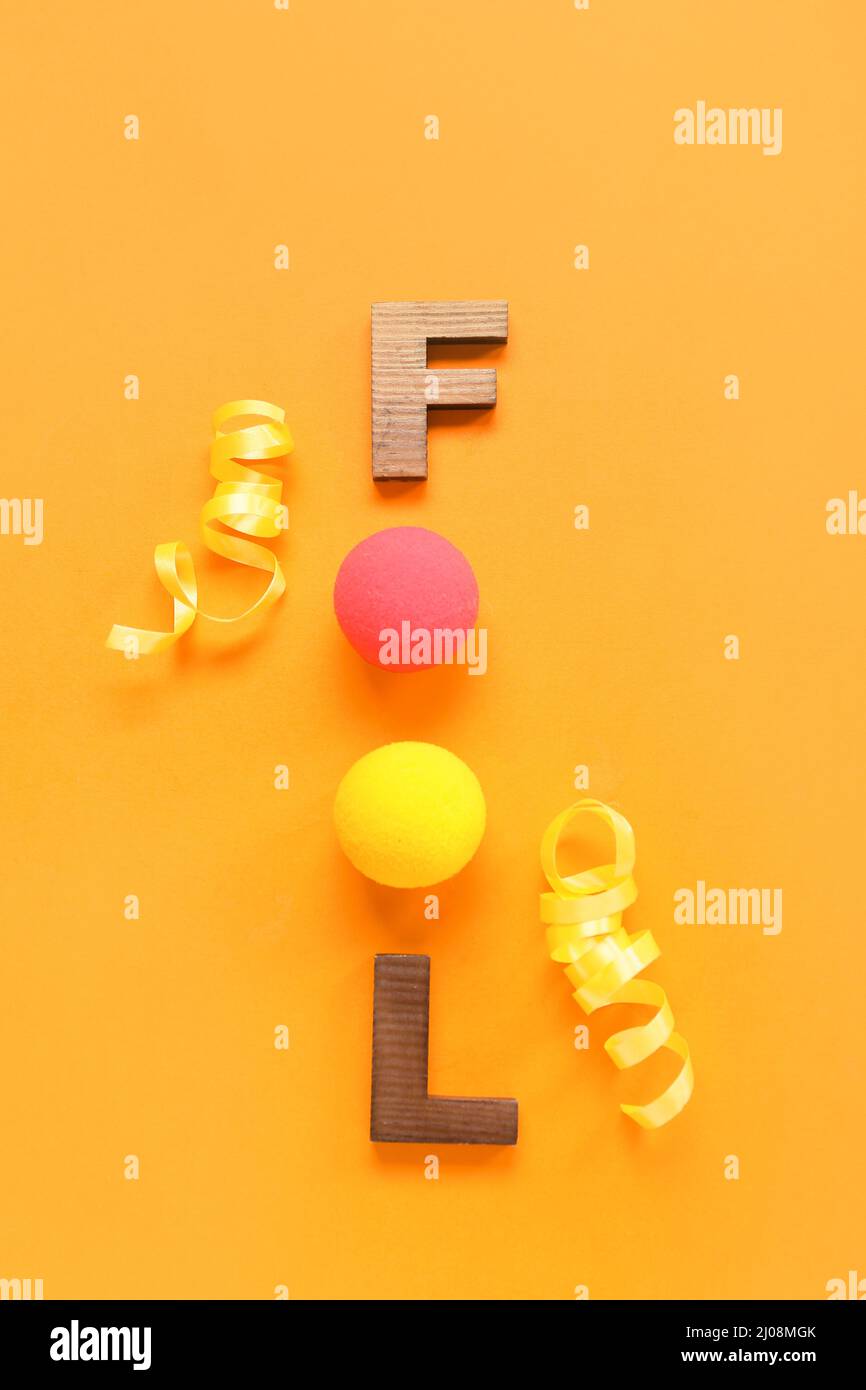 Word FOOL made of clown noses and confetti on orange background Stock ...