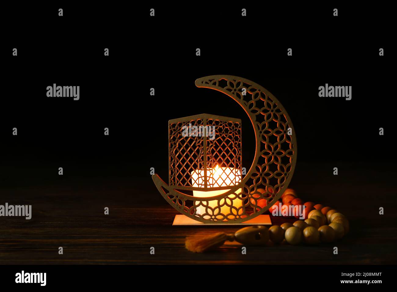 Arabic candle holder with glowing candle and tasbih on dark background ...