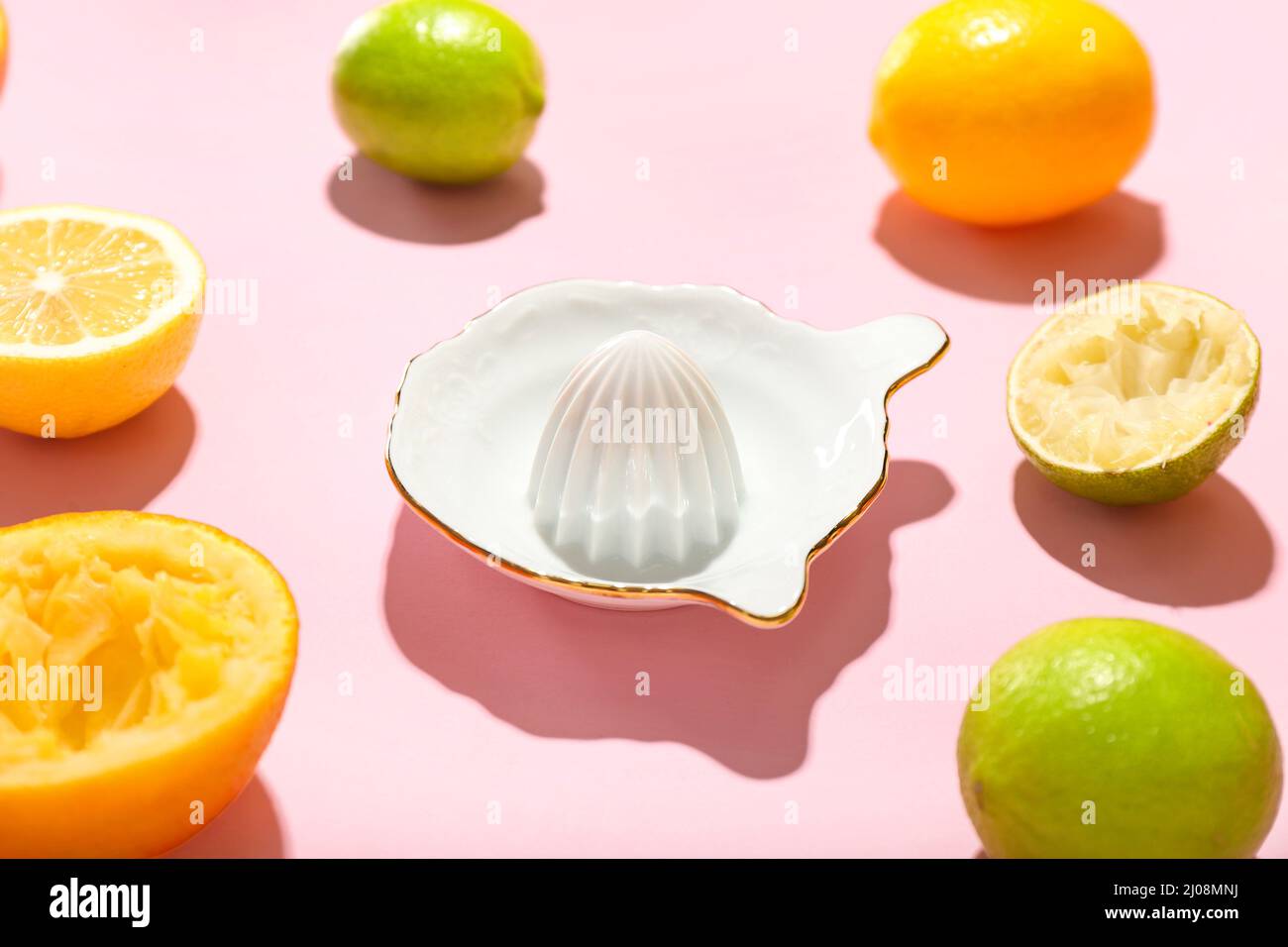 Ceramic juicer and citrus fruits on pink background Stock Photo - Alamy