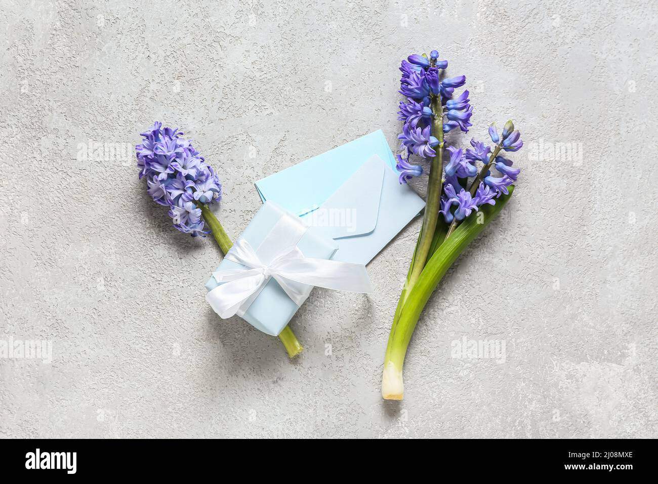 Beautiful hyacinth flowers, gift box and envelopes on light background ...