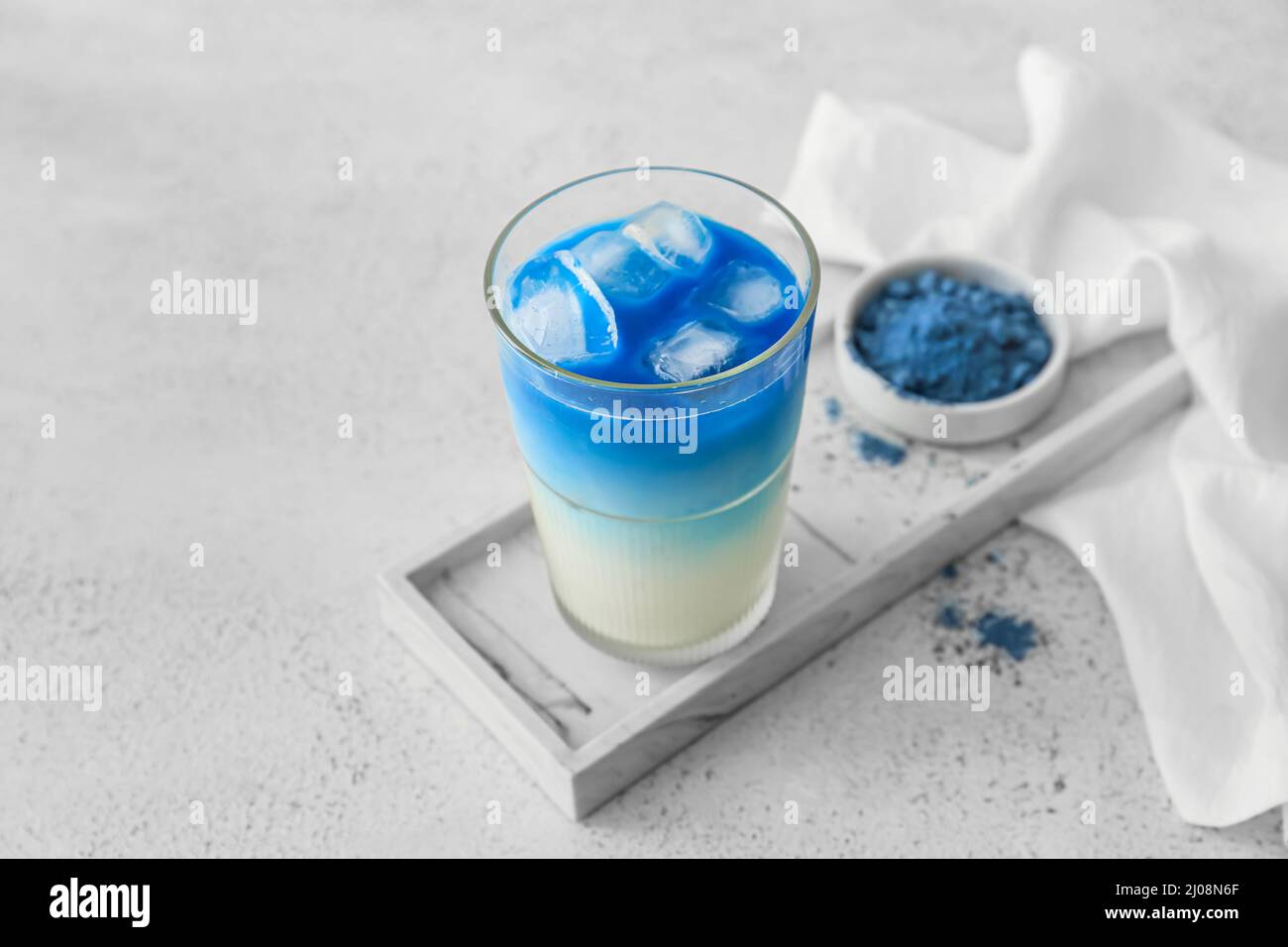 Glass of blue matcha tea and bowl with powder on light background Stock ...