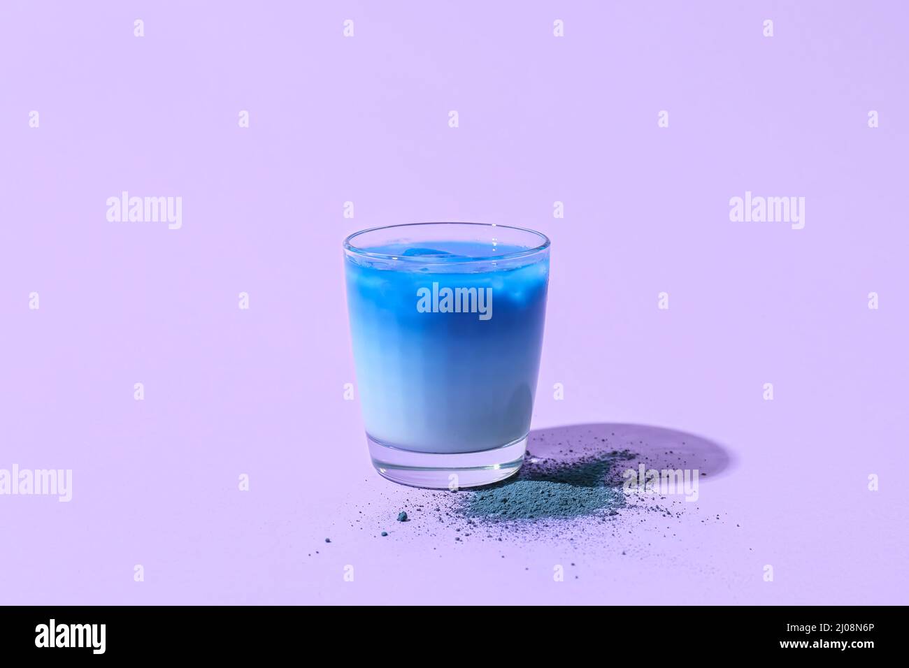 Glass of blue matcha tea and powder on purple background Stock Photo ...