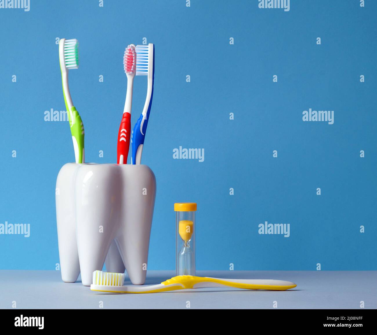 Toothbrushes are in a glass, there is an hourglass next to it, to count ...