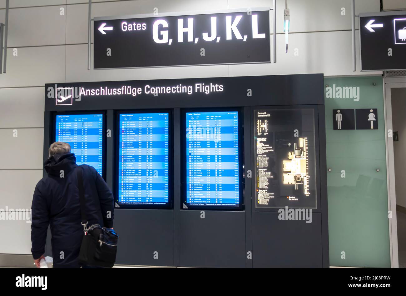 Passenger in front of departure connecting flights information, Munich ...